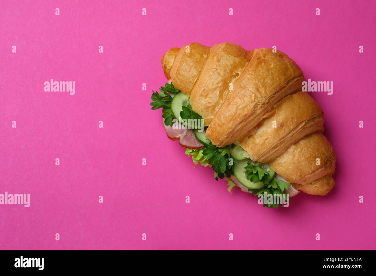 Tasty croissant sandwich on pink background, space for text Stock Photo ...