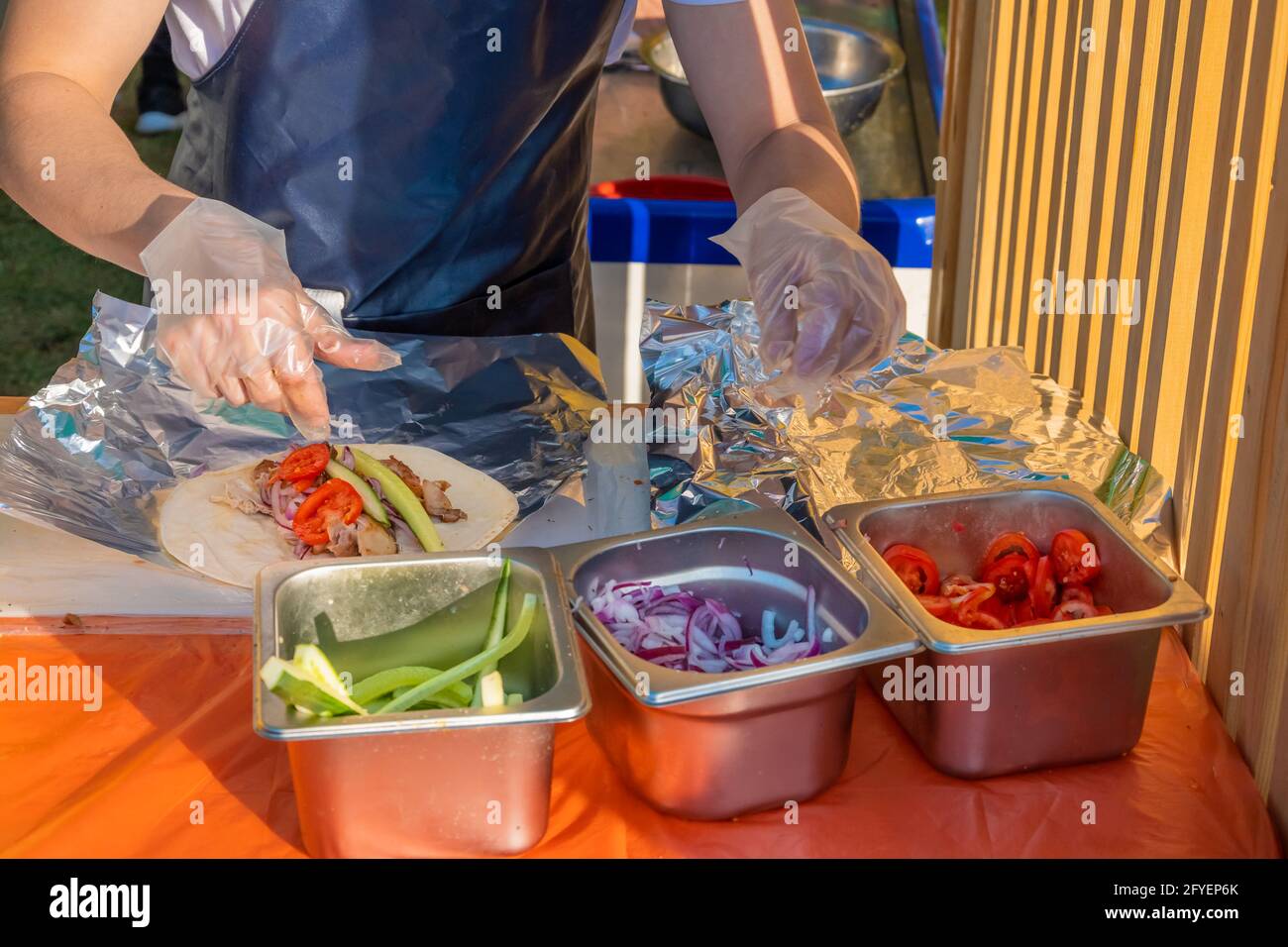 A professional chef fills the gyros with stuffing. Barbecue festival in ...