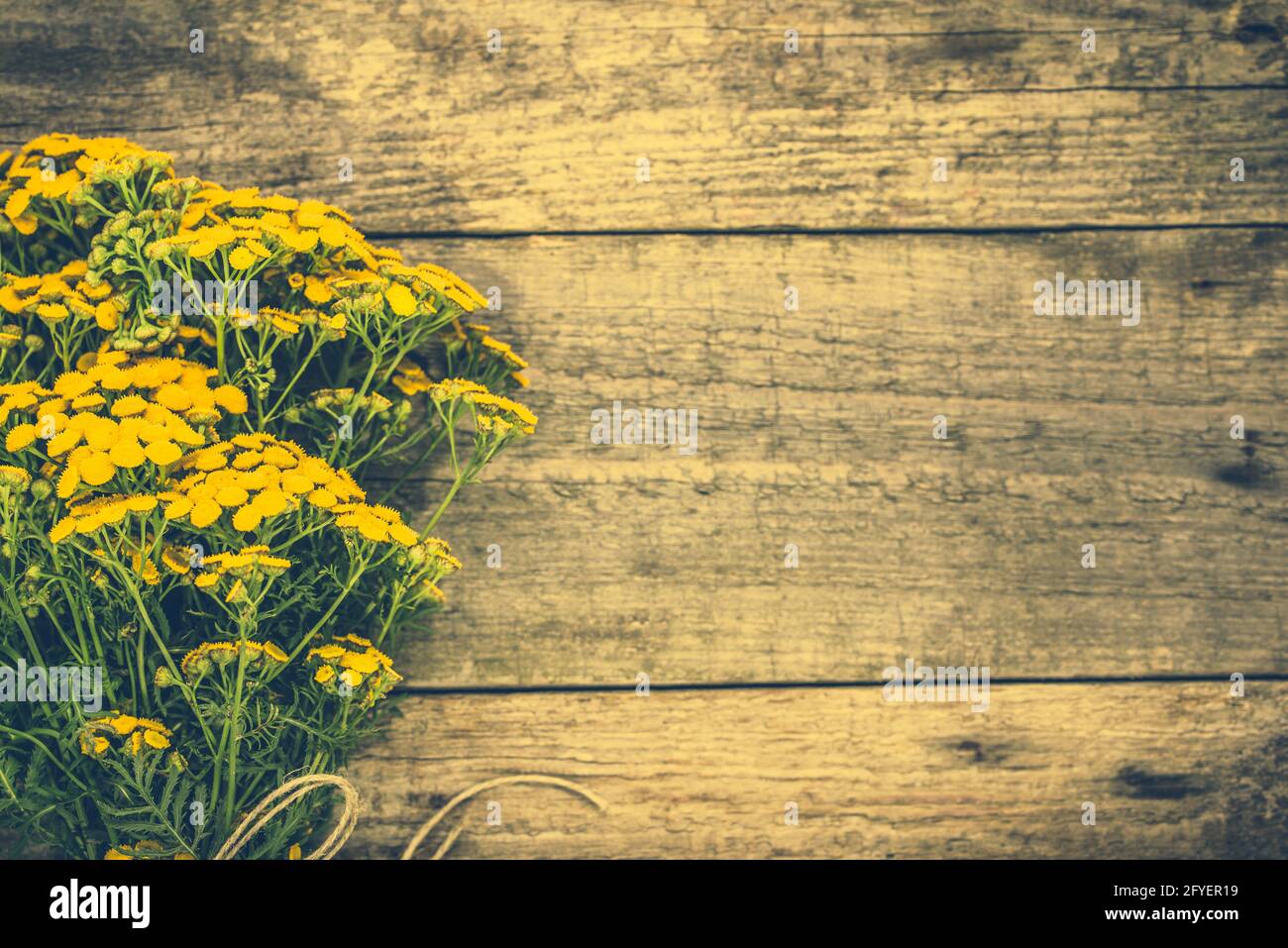 Yellow flowers from summer meadow, rustic bouquet located on wooden ...