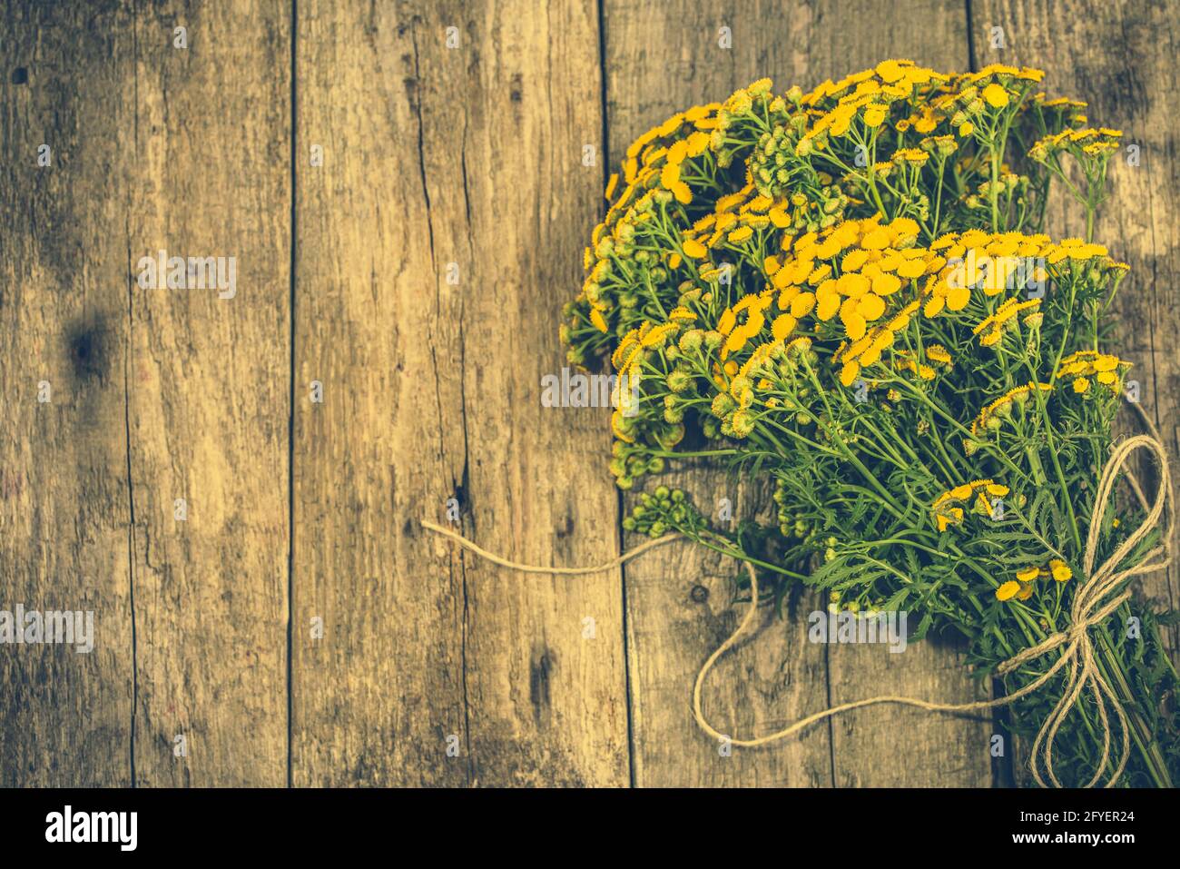 Yellow flowers from summer meadow, rustic bouquet located on wooden ...