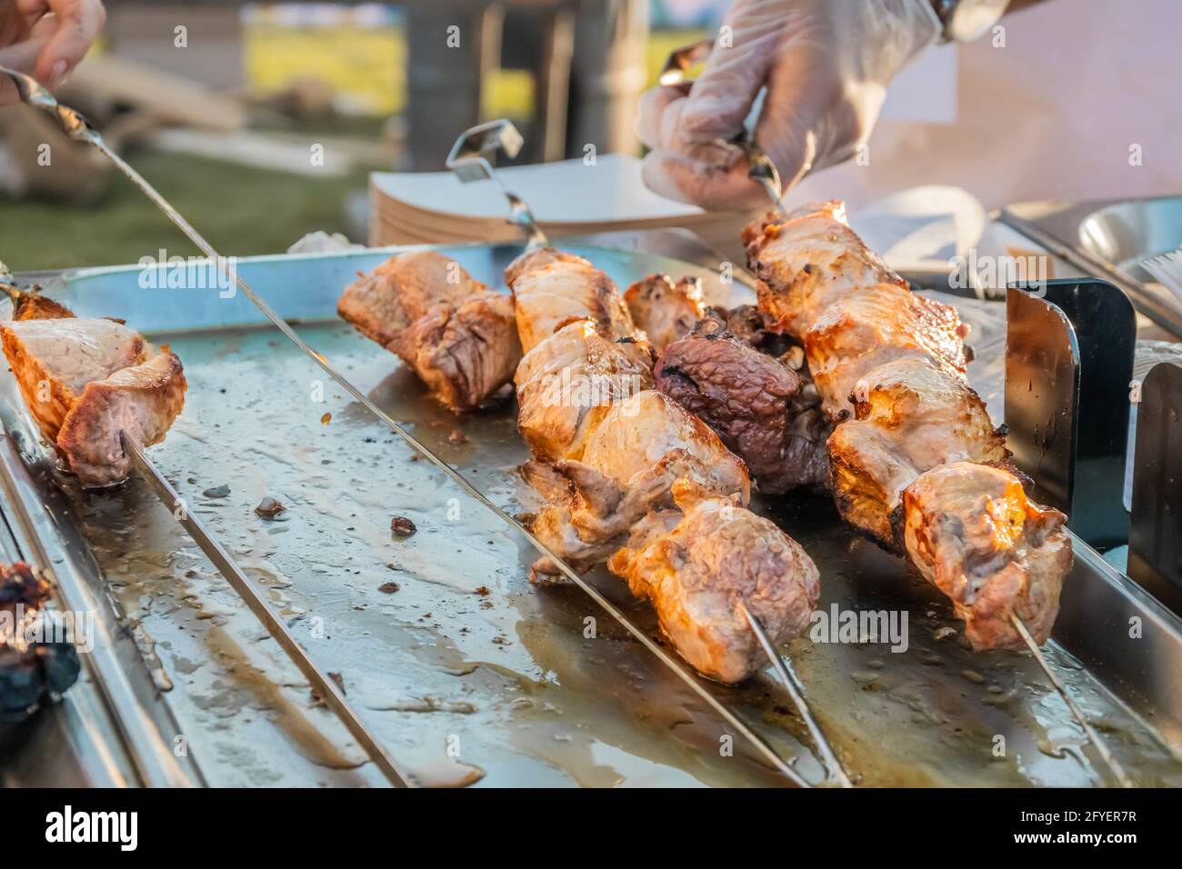 Fried shish kebab on skewers on the counter of a street restaurant ...