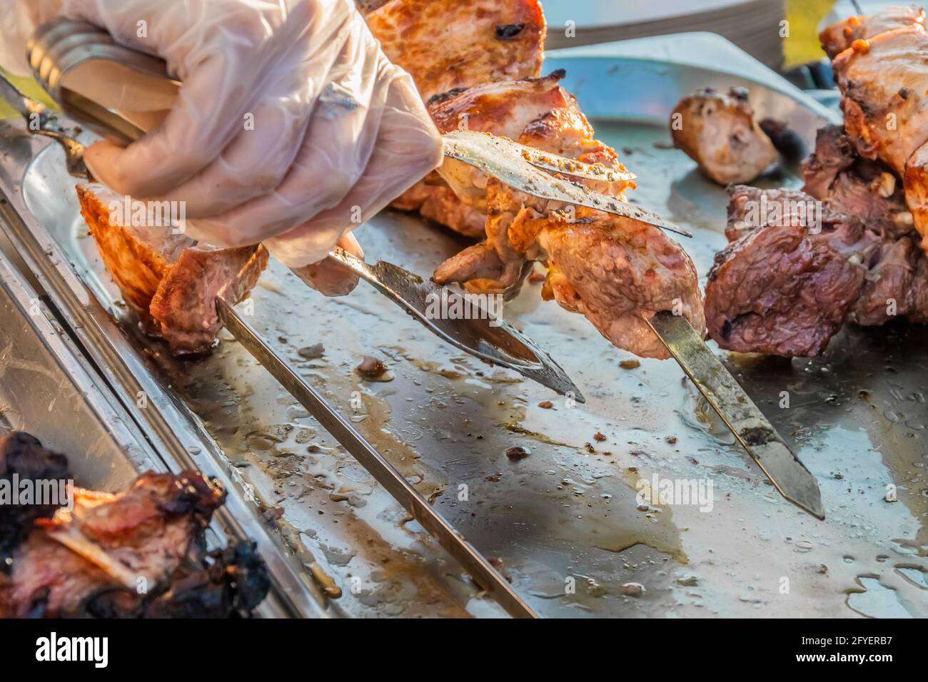 Fried shish kebab on skewers on the counter of a street restaurant ...