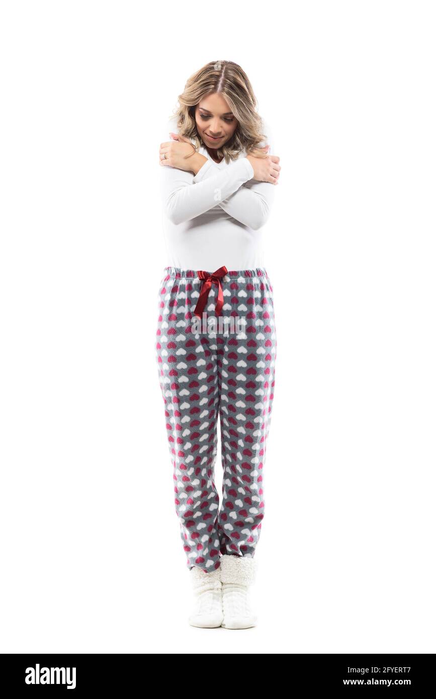 Cute feminine young woman feeling cold self hugging looking down and ...