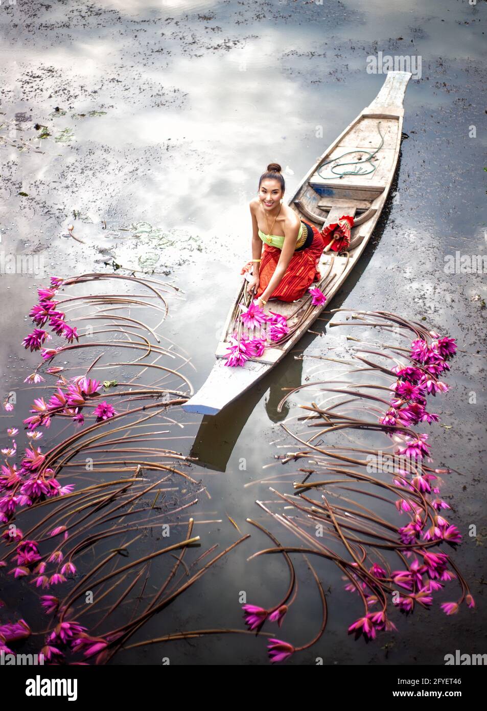 Young Asian women in Traditional dress in the boat and pink lotus ...