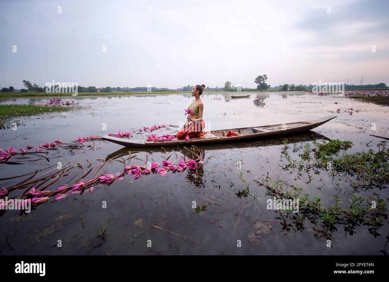 Young Asian women in Traditional dress in the boat and pink lotus ...