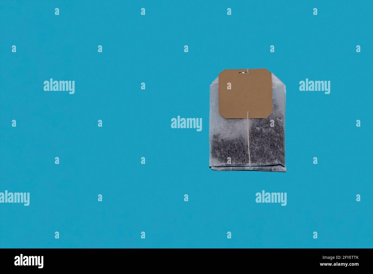 Disposable tea bag with tag. Front view from above is Isolate on blue ...