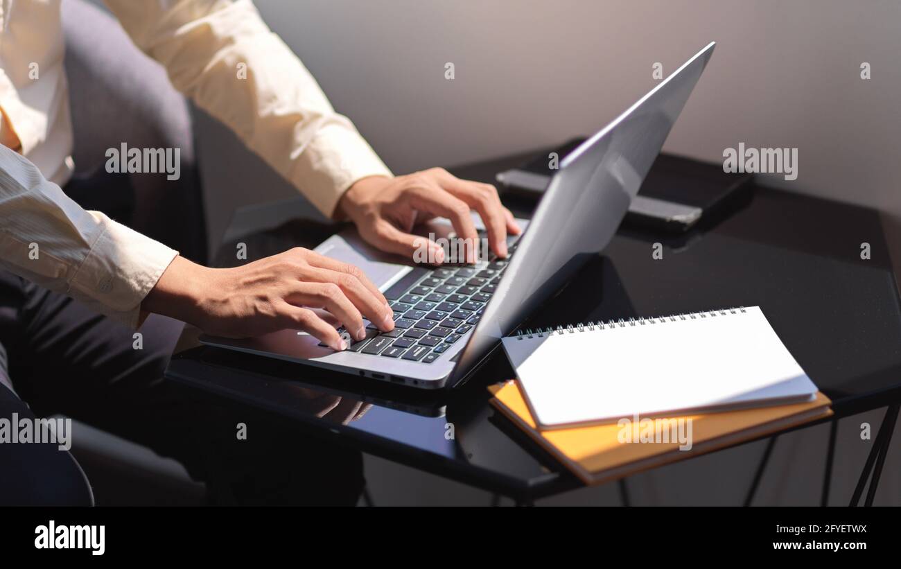 Side view of businessman hands typing on laptop keyboard on portable ...