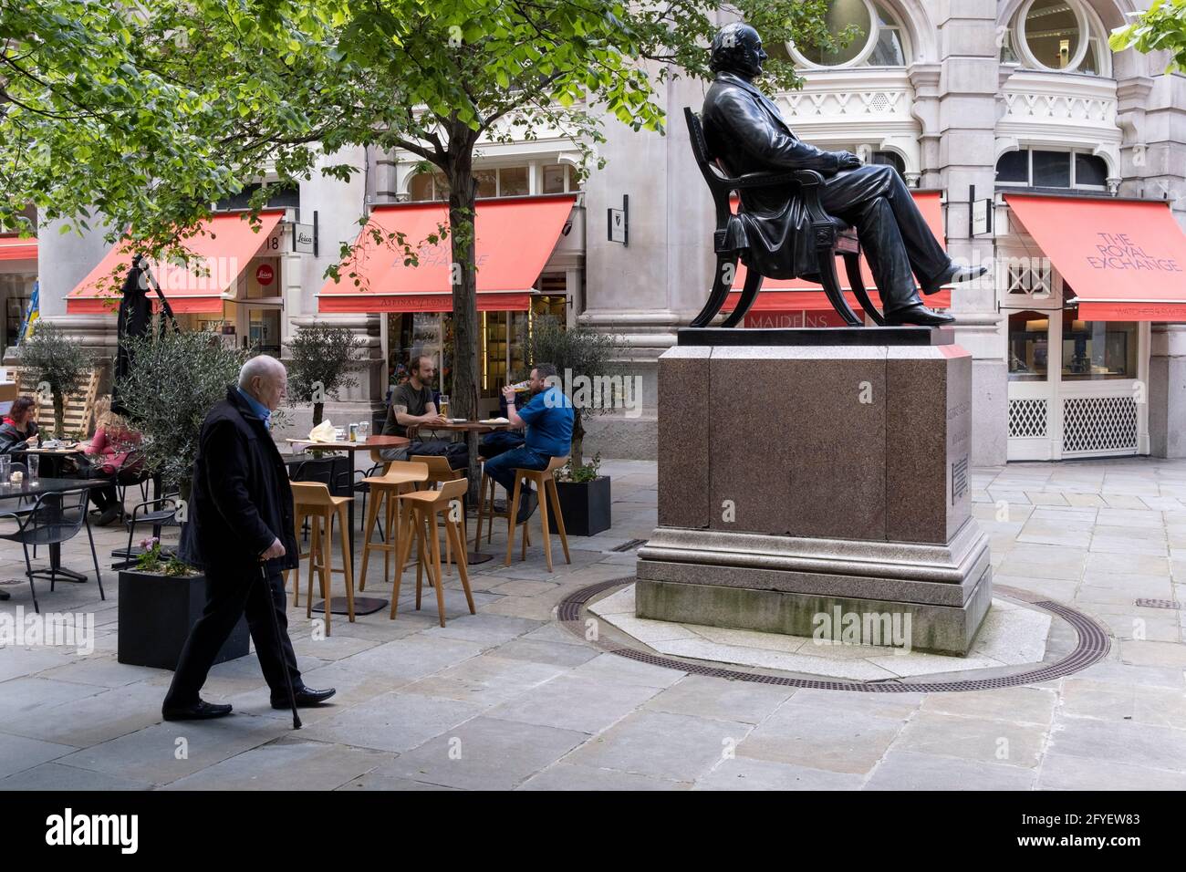Pedestrians and lunchtime drinkers alongside the statue of Victorian ...