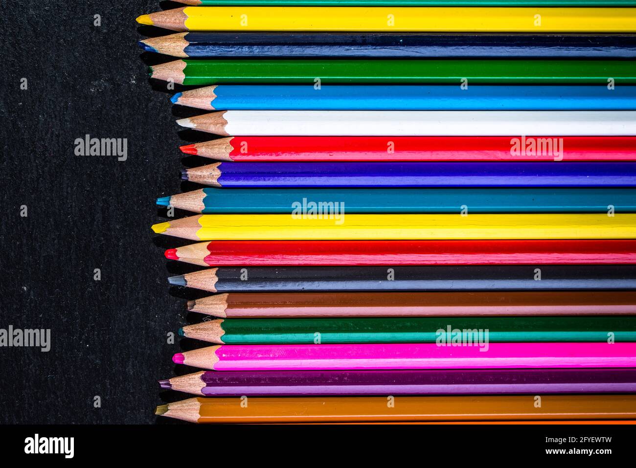 Colorful school supplies background, colored pencils on black, back to ...