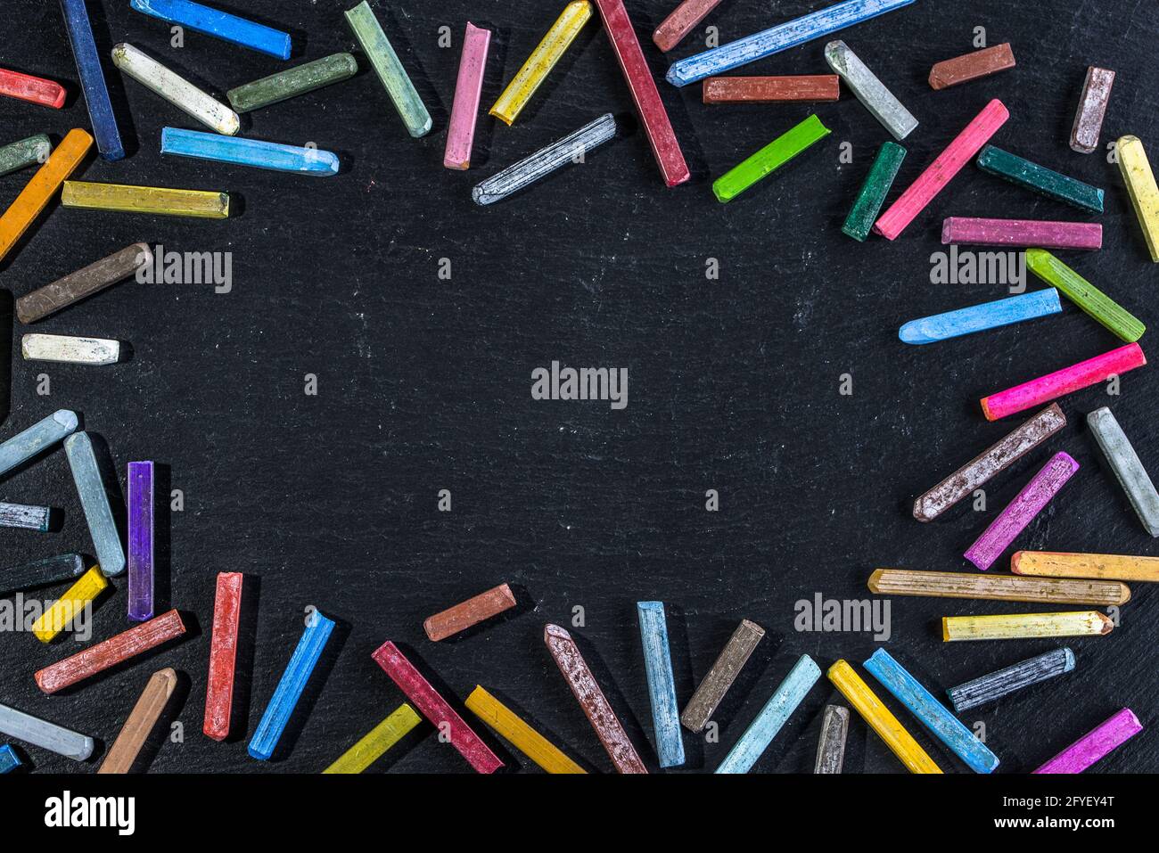 Colorful frame with chalk on chalkboard black background with space for ...