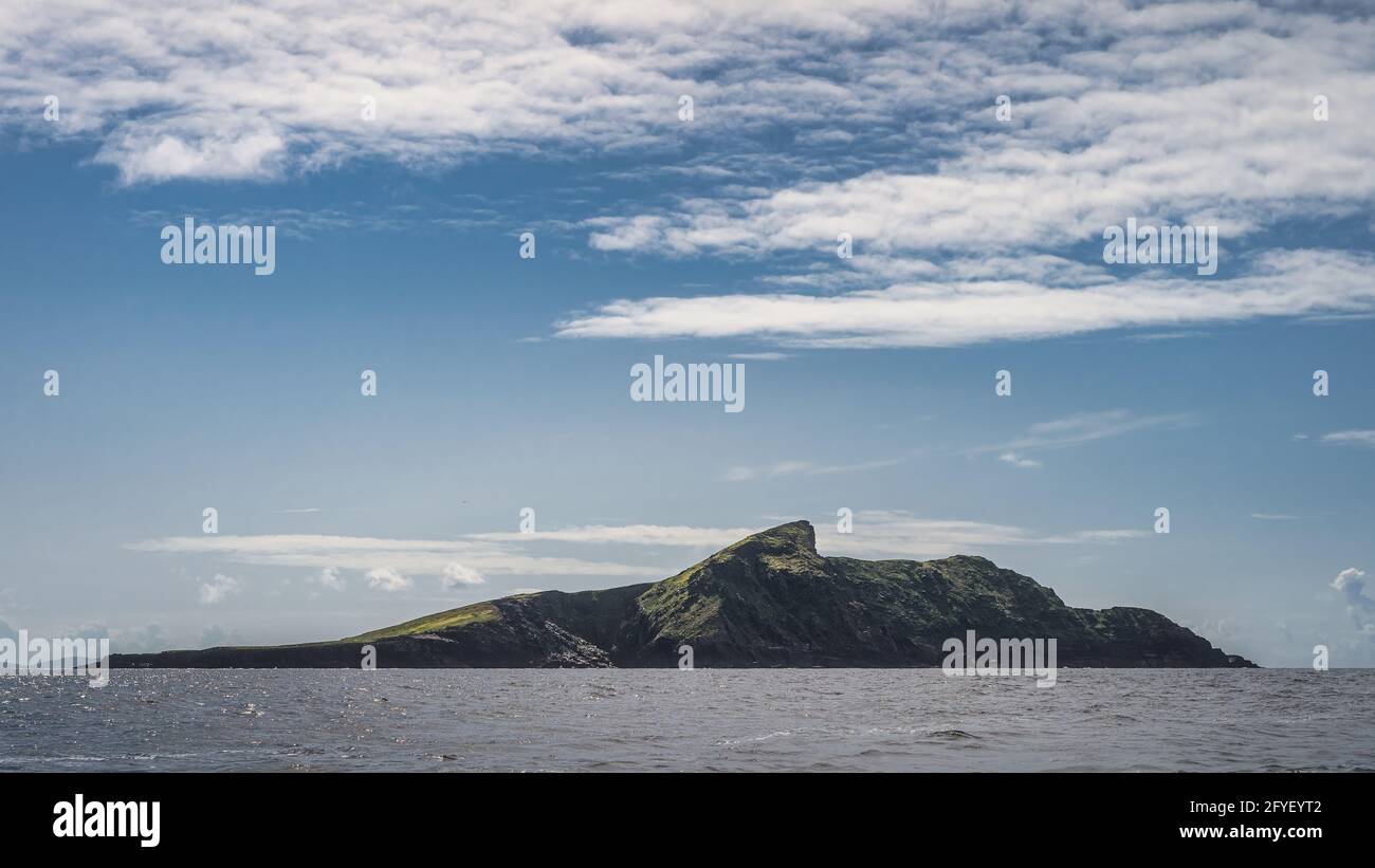 Small rocky island of Irish coastline near Kerry Cliffs, seen from boat ...