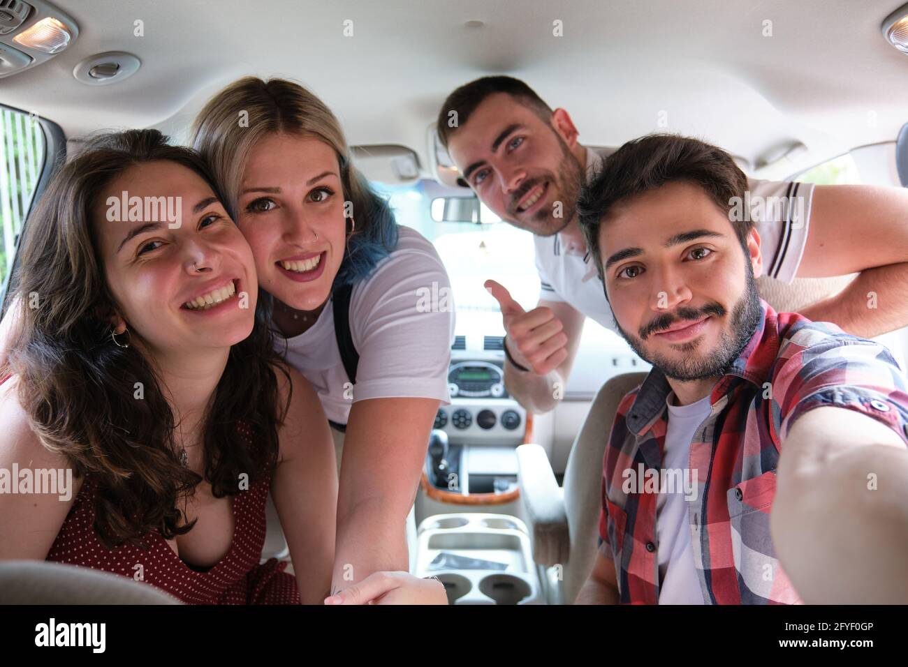 Group of friends taking a selfie into the car before leaving for ...