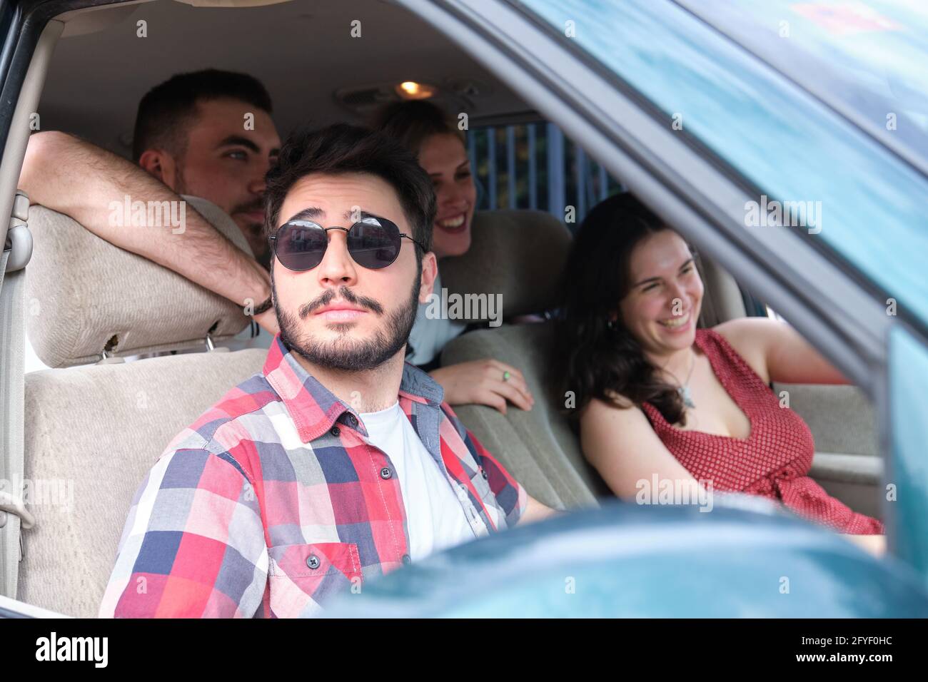 Group of friends travel together driving a car and making fun. Summer ...