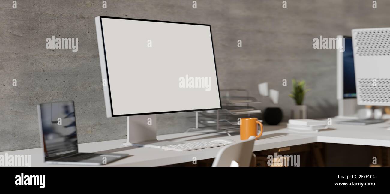 Side view of comfortable office desk with computer monitor, laptop and ...