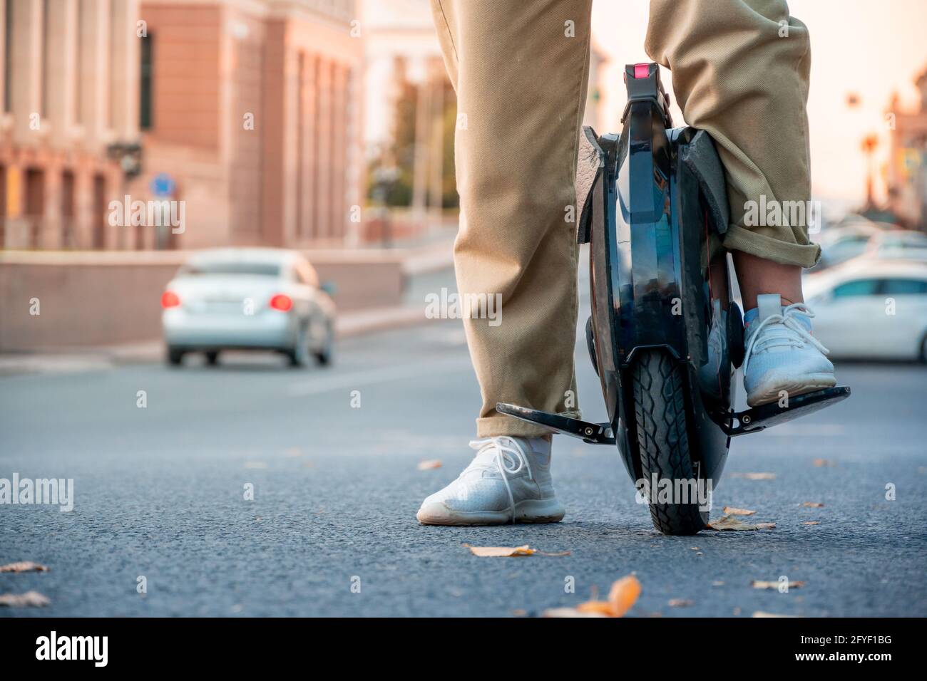 The legs of a young woman ready to ride an electric unicycle ...