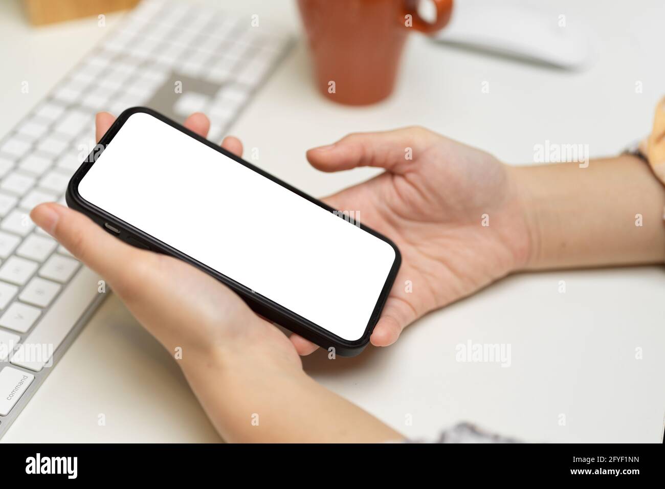 Side view of female hands holding smartphone with mock-up screen on ...