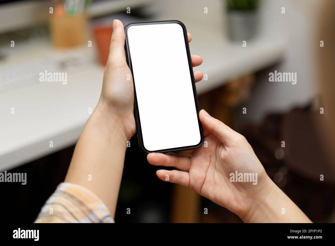 Close up view of female hands holding smartphone with mock-up screen at ...