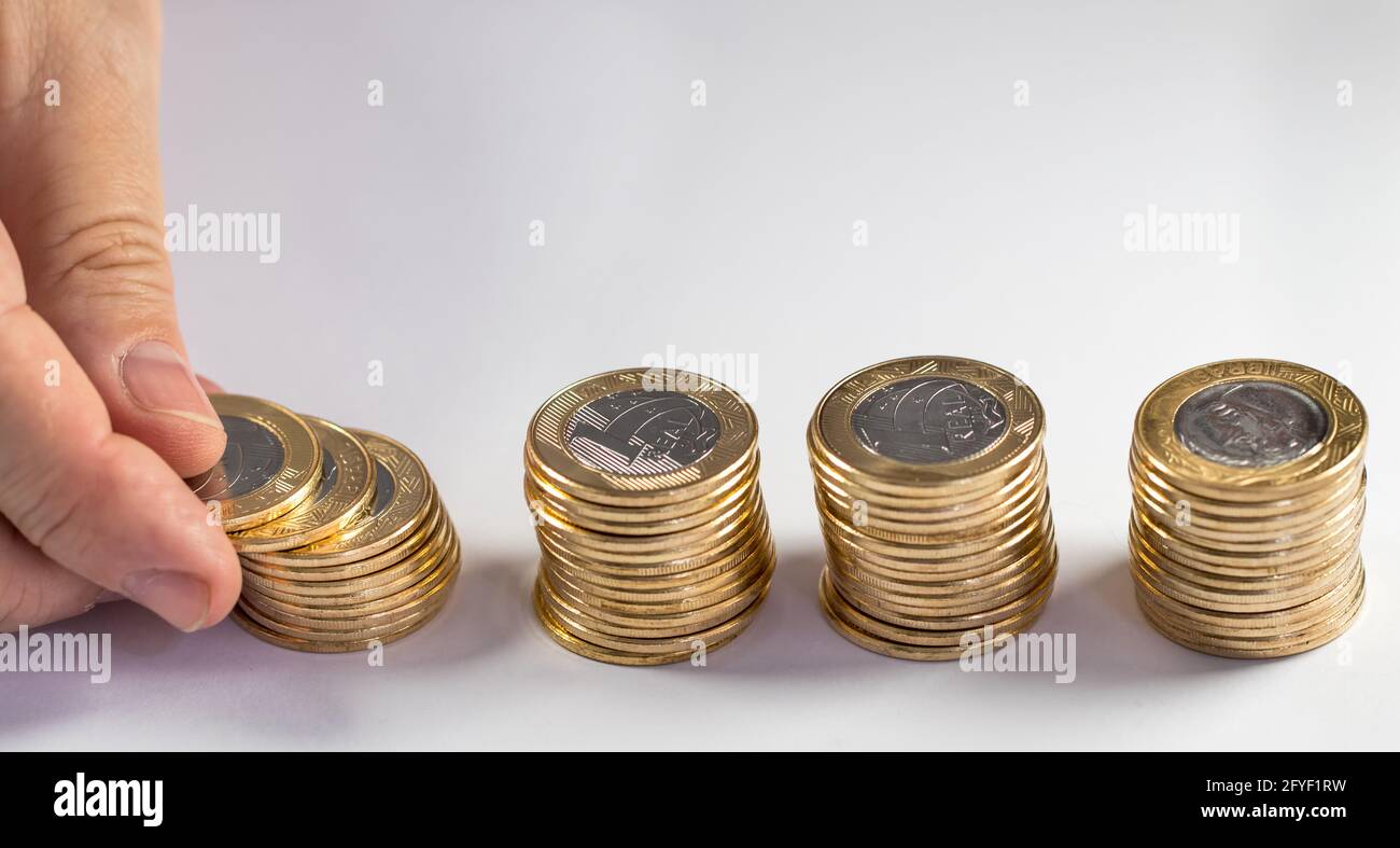 Person stacking some Brazilian coins Stock Photo - Alamy