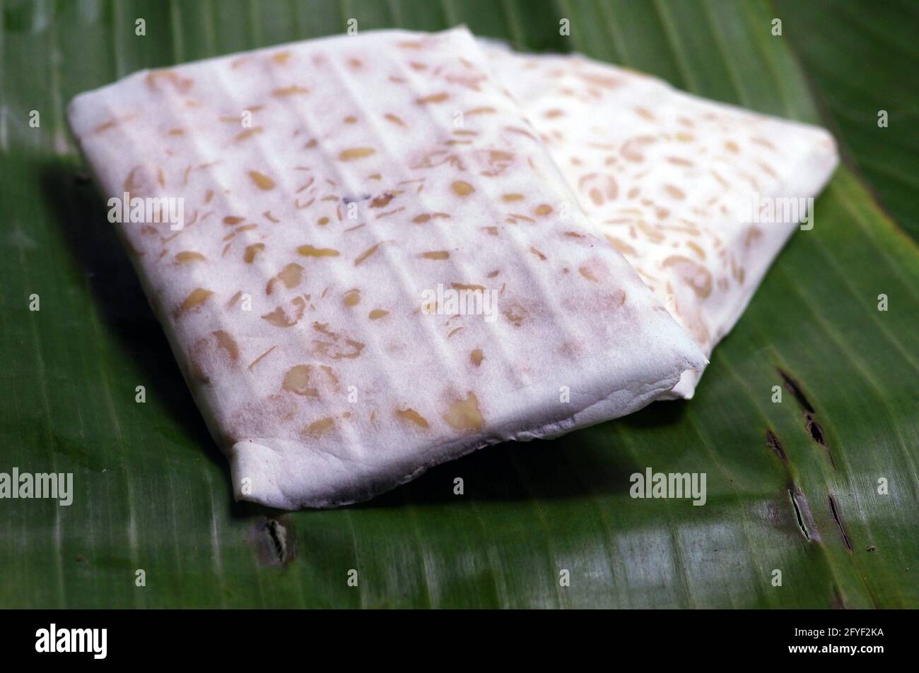 Raw Tempe, on green banana leaves, shallow focus. Tempe is a ...
