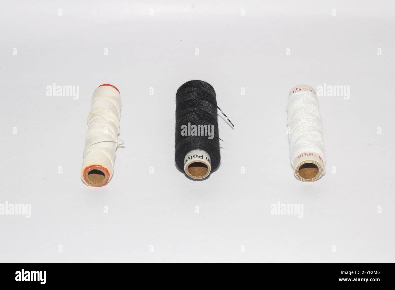 Closeup shot of black and white sewing threads isolated on a white ...