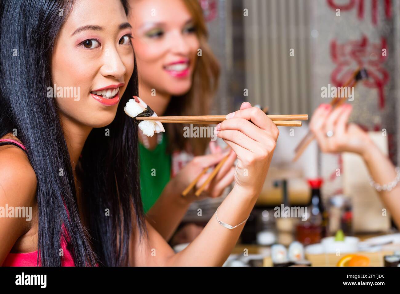 Young people eating sushi in Asian restaurant Stock Photo - Alamy