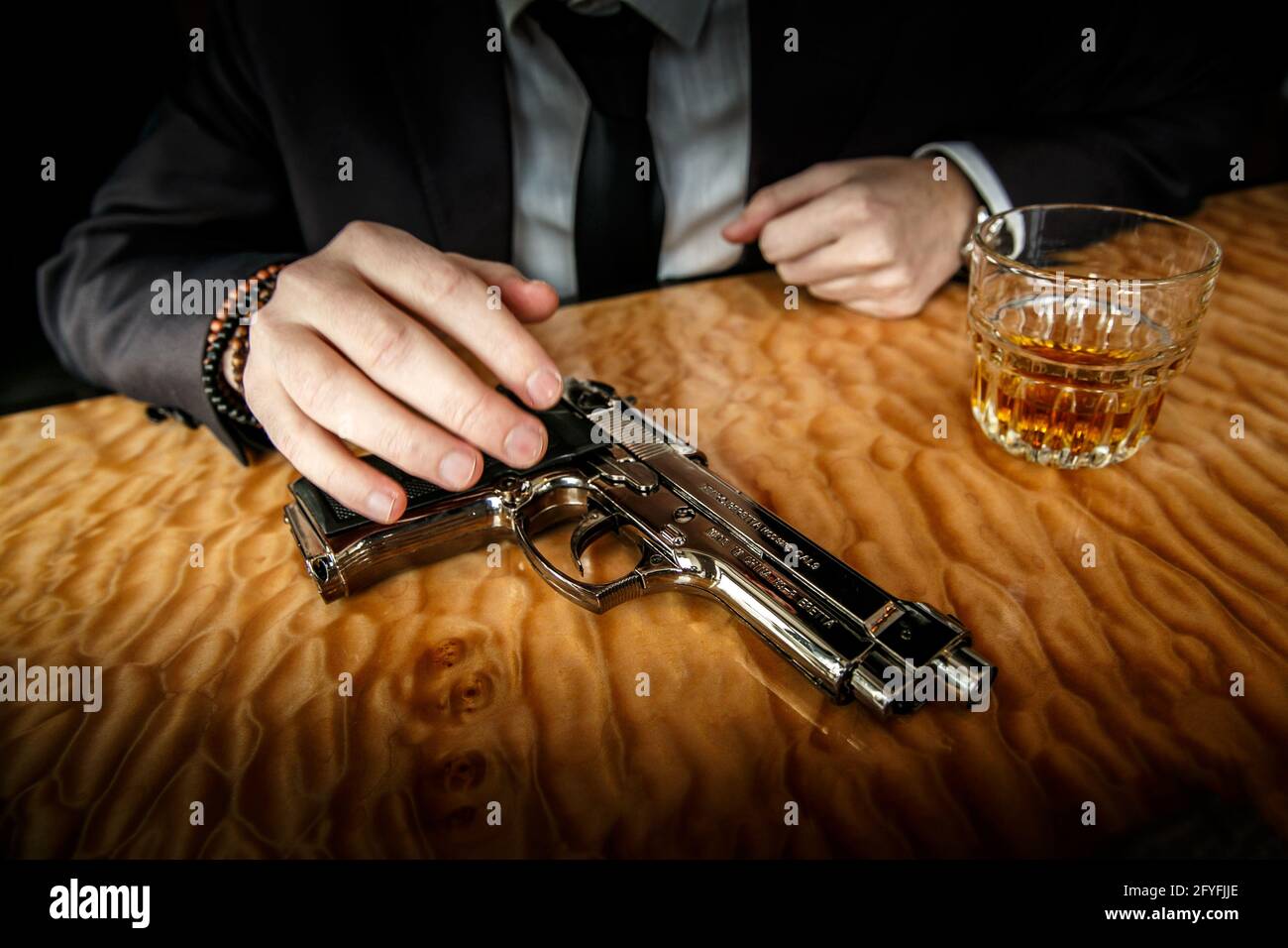 Black gun on brown table hi-res stock photography and images - Alamy