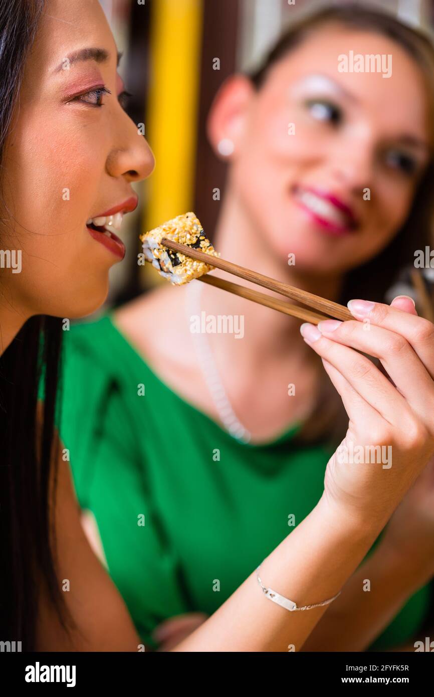 Young people eating sushi in Asian restaurant Stock Photo - Alamy