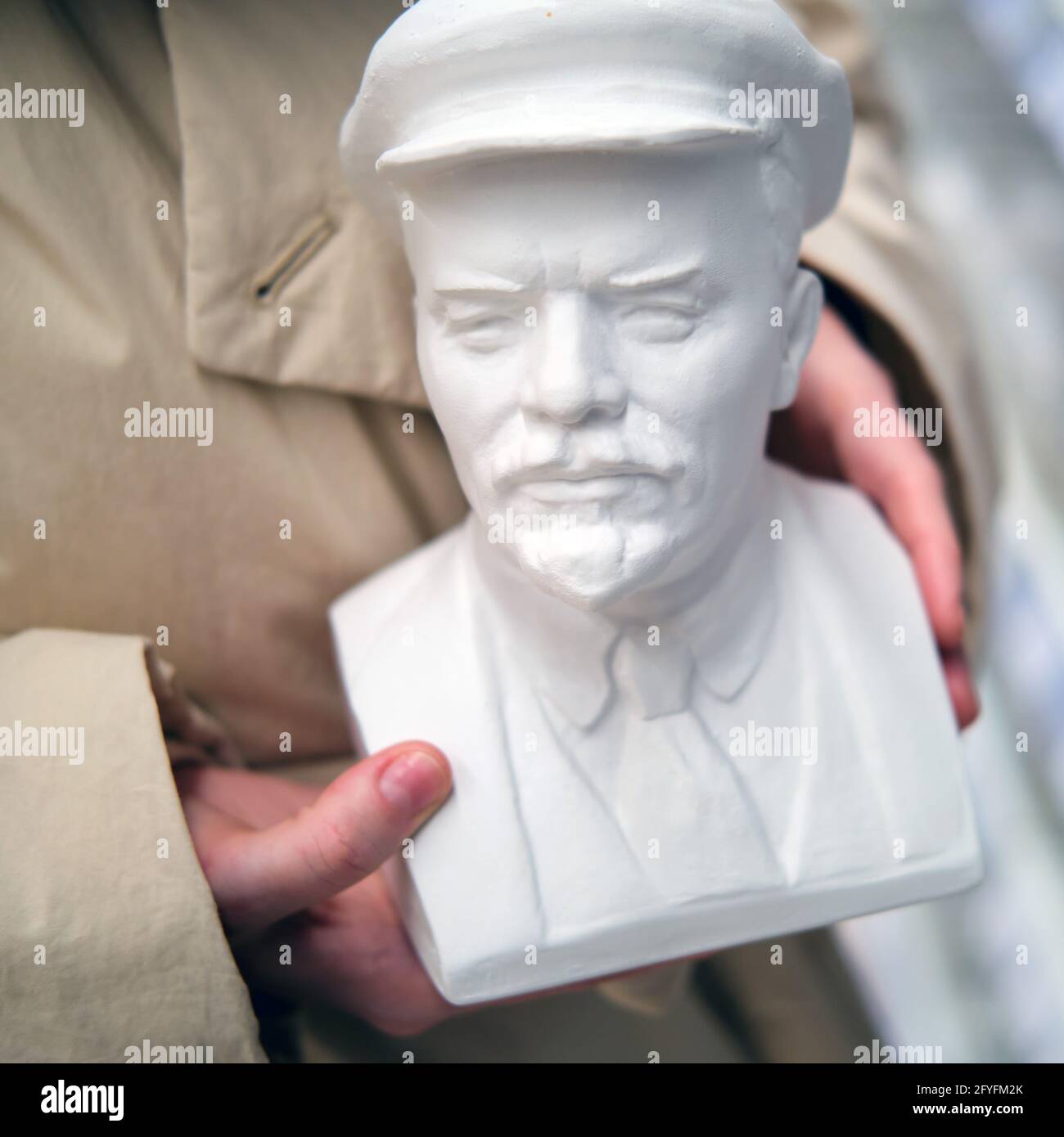 A bust of Vladimir Ilyich Lenin is sold in a store, a woman holds a ...