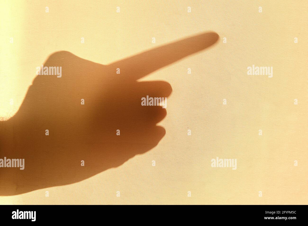The shadow of a man hand shows a gesture with a finger forward ...