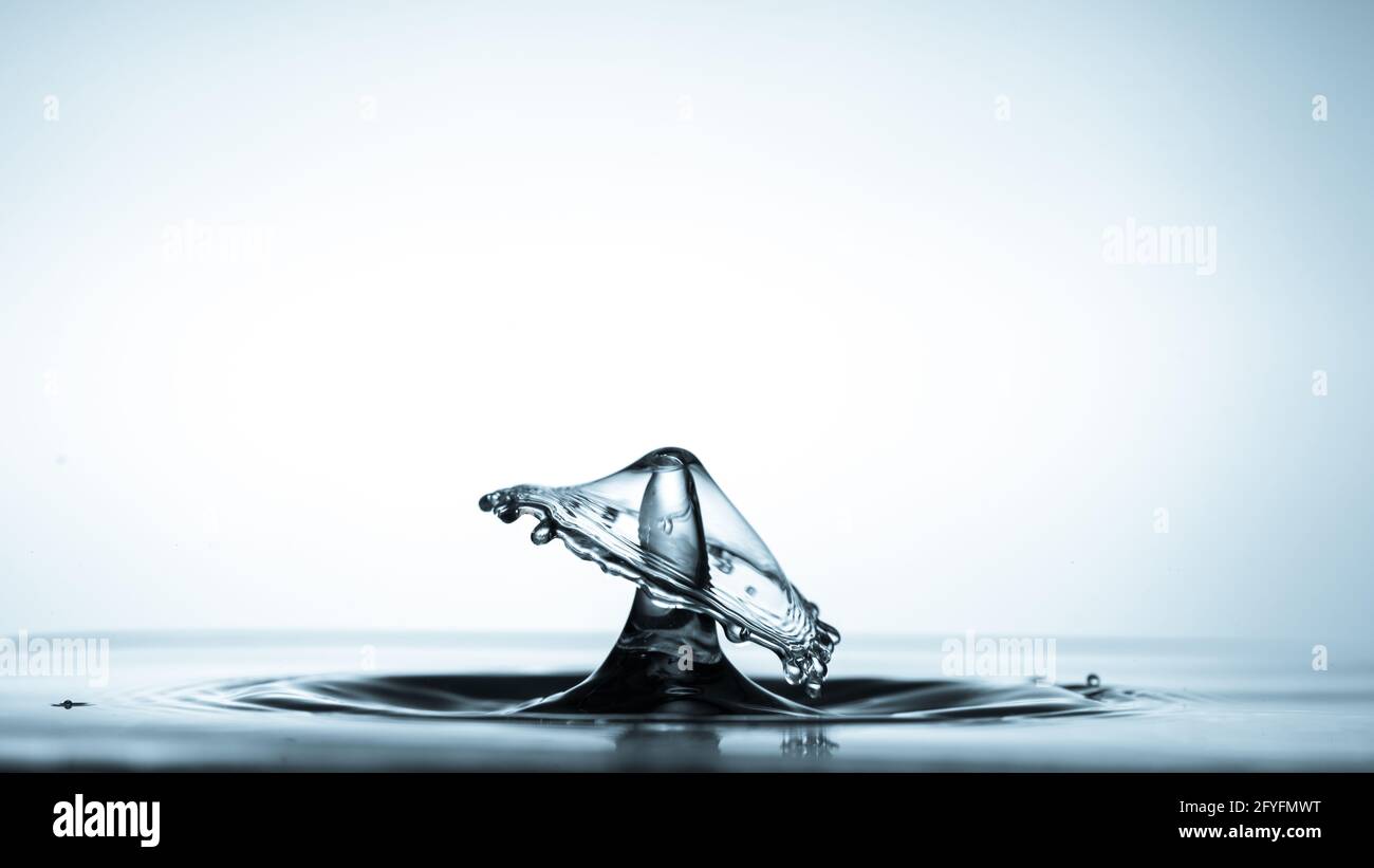 Close-up of a water drop falling on water surface Stock Photo - Alamy