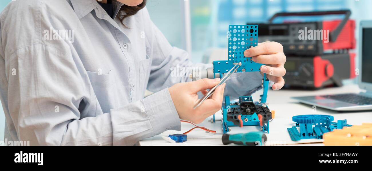 Student woman in robotics laboratory working on project mechatronics ...