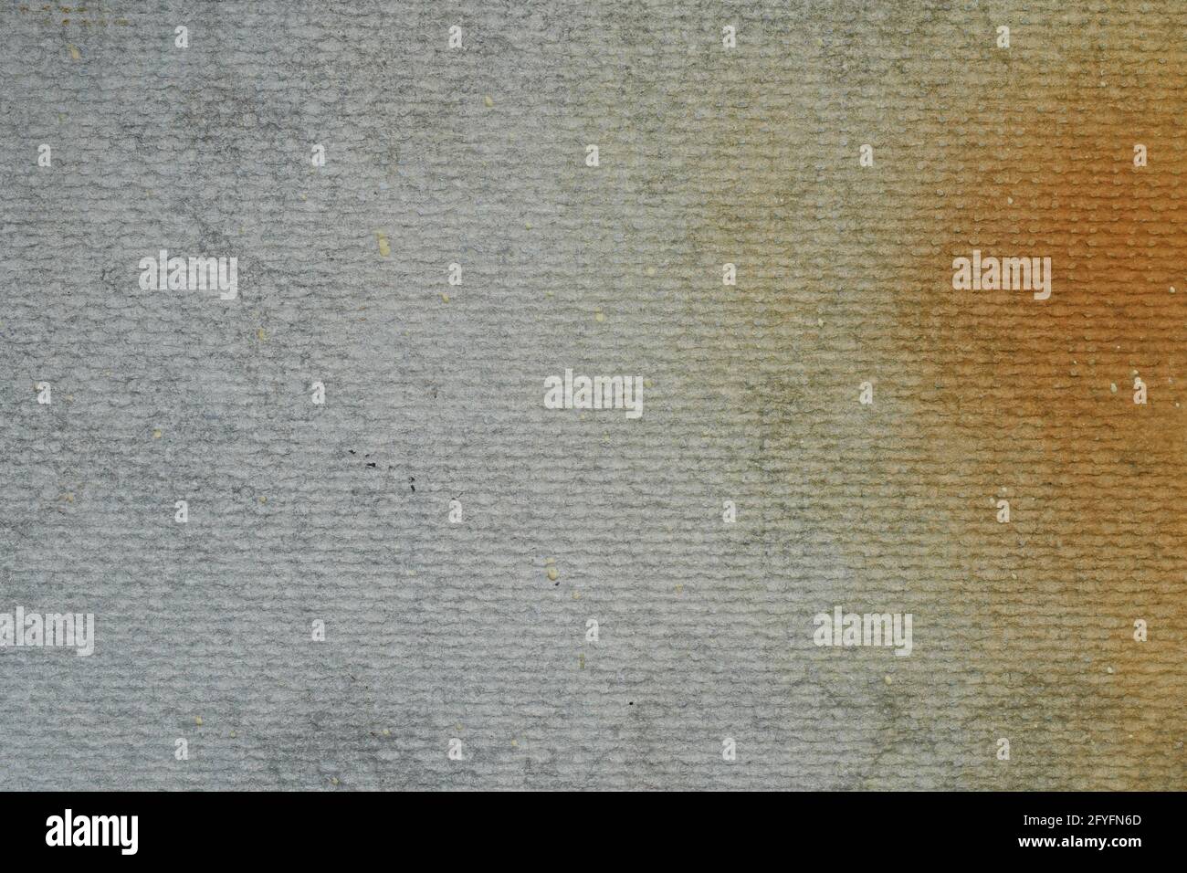 The textured surface of a smooth slate sheet with a red rust stain ...