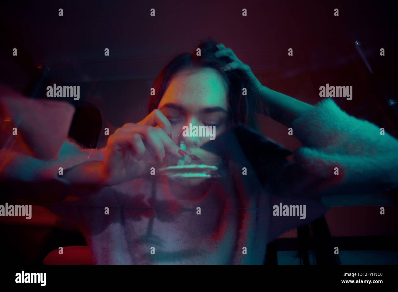 Portrait of a girl sniffing a line of white drug cocaine powder. Addict ...