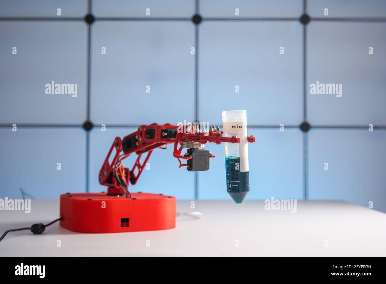 Robot arm with test tube with biological sample in science laboratory ...