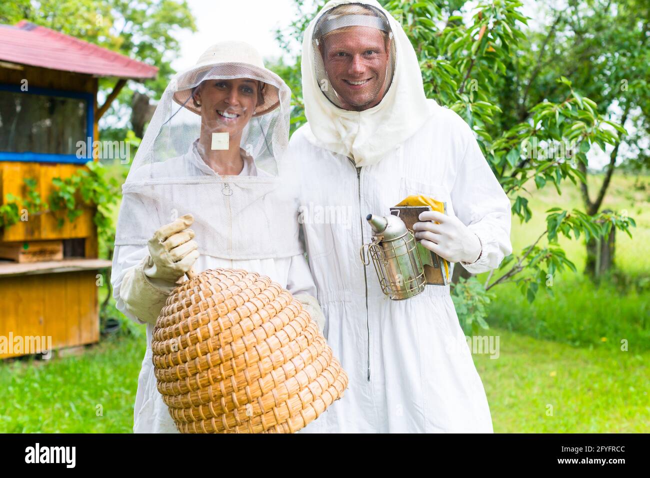 Beekeeper team working outdoor with smoker and beehive Stock Photo - Alamy