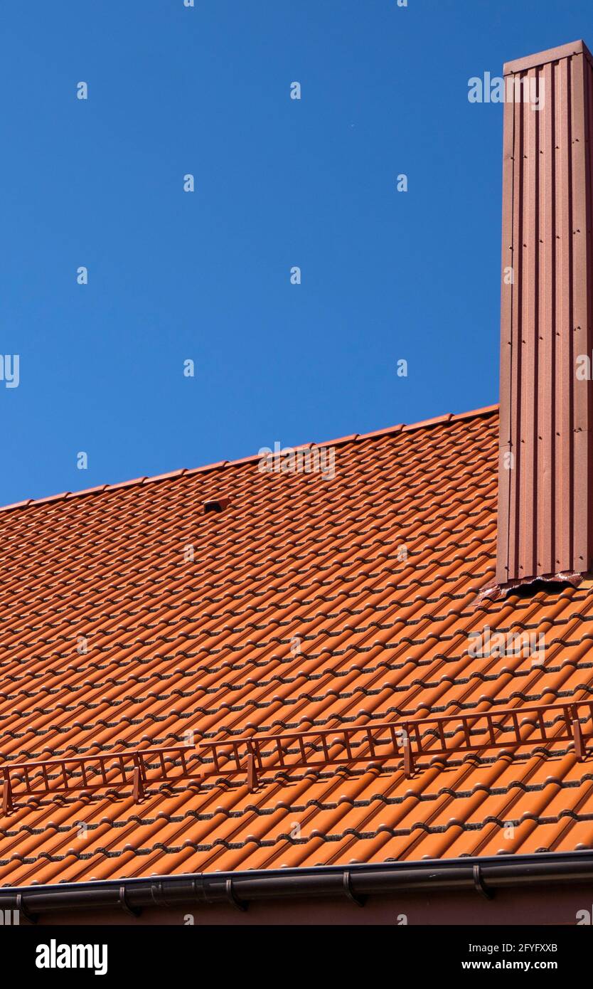 Red corrugated metal profile roof installed on a modern house. The roof ...