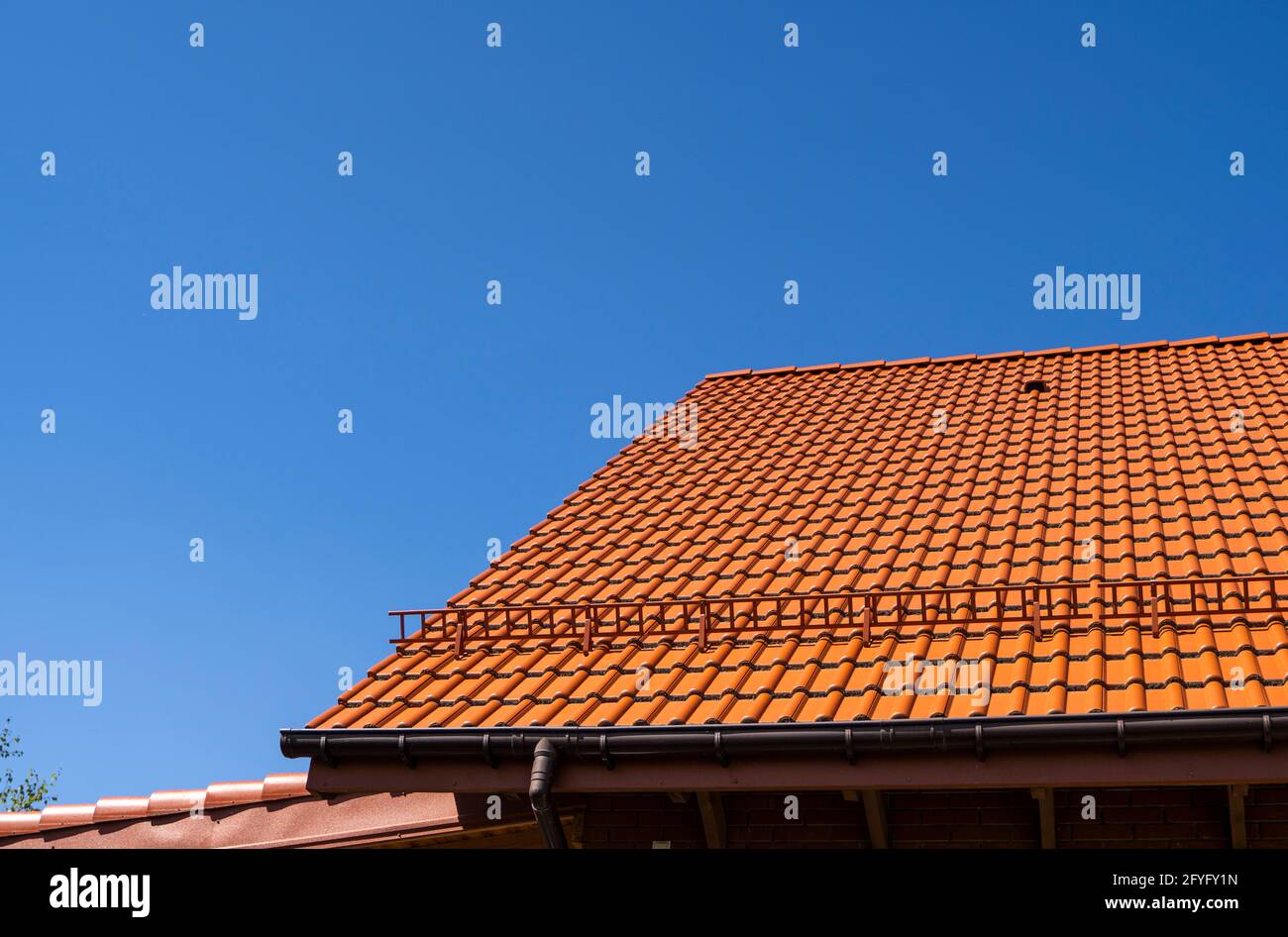 Red corrugated metal profile roof installed on a modern house. The roof ...