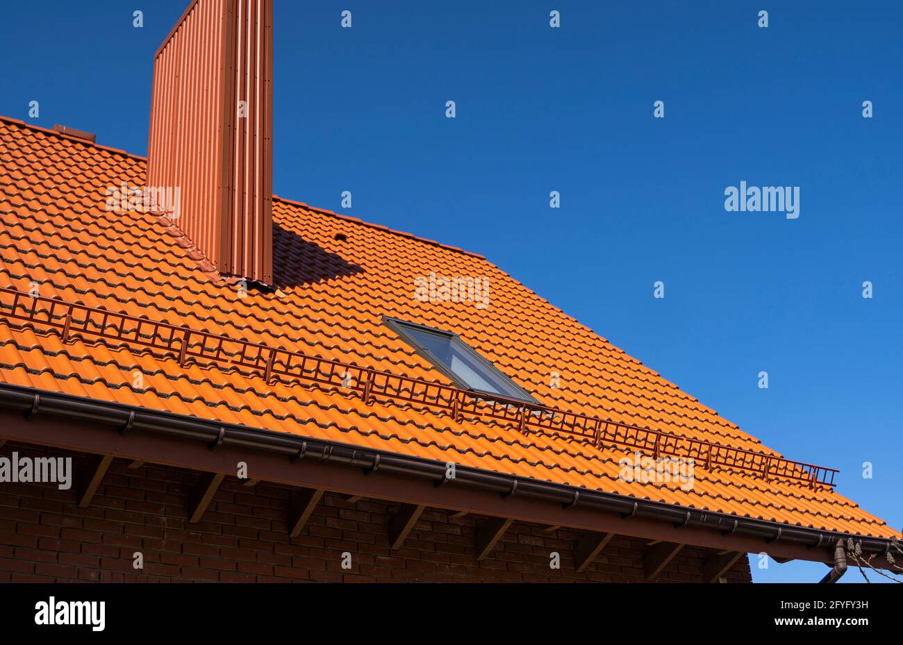 Red corrugated metal profile roof installed on a modern house. The roof ...