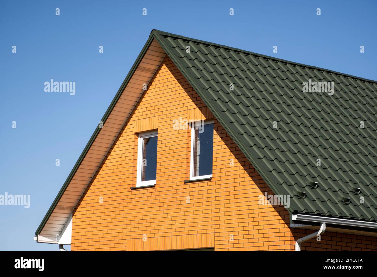 Green corrugated metal profile roof installed on a modern house. The ...