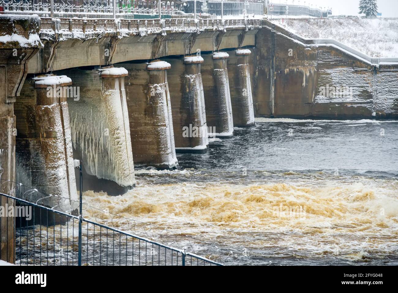 Water flow at a hydroelectric power station on a frosty winter day ...