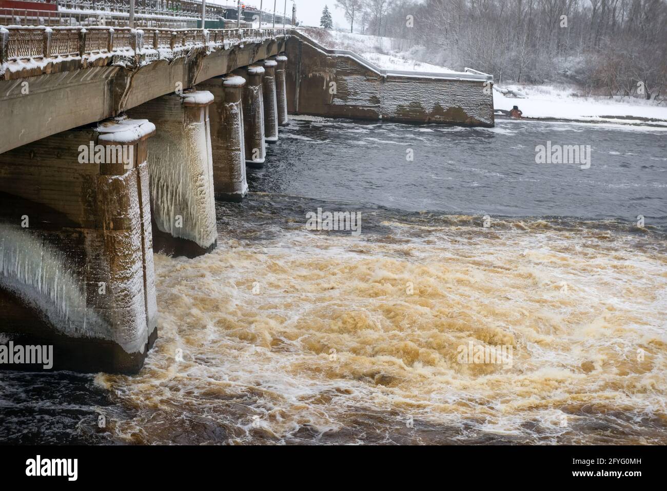 Water flow at a hydroelectric power station on a frosty winter day ...