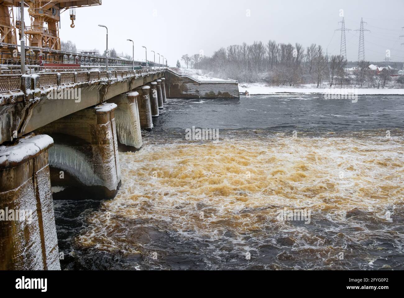 Water flow at a hydroelectric power station on a frosty winter day ...