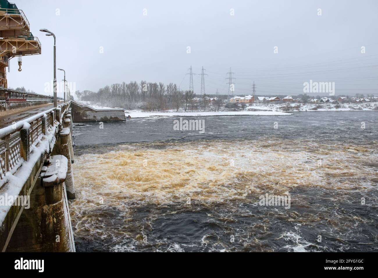Water flow at a hydroelectric power station on a frosty winter day ...