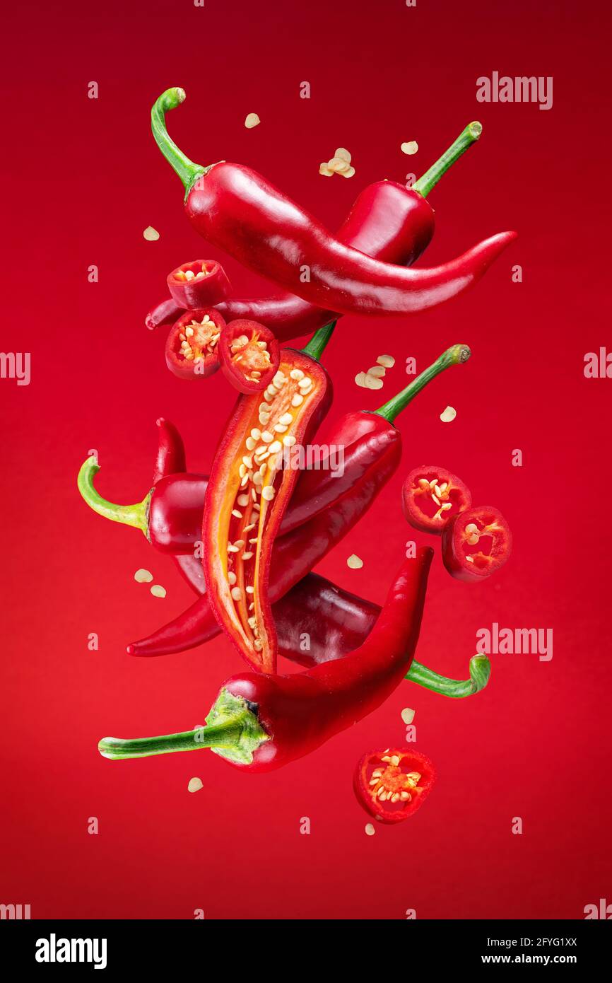 Fresh red chilli peppers and cross sections of chilli pepper with seeds ...