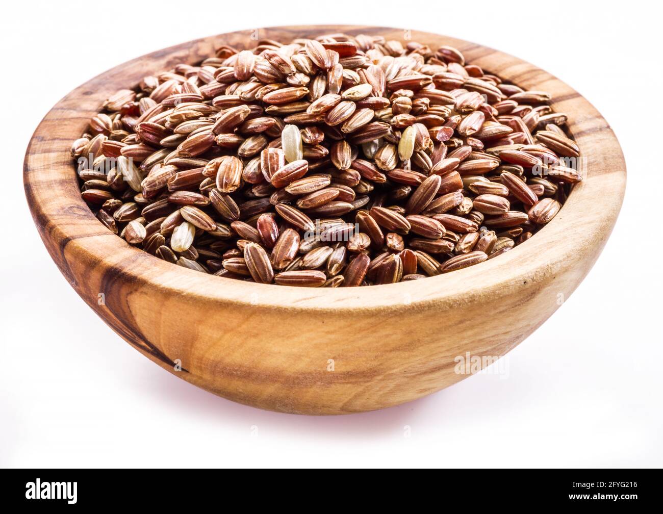 Brown rice - whole grain rice with outer hull or husk in wooden bowl on ...