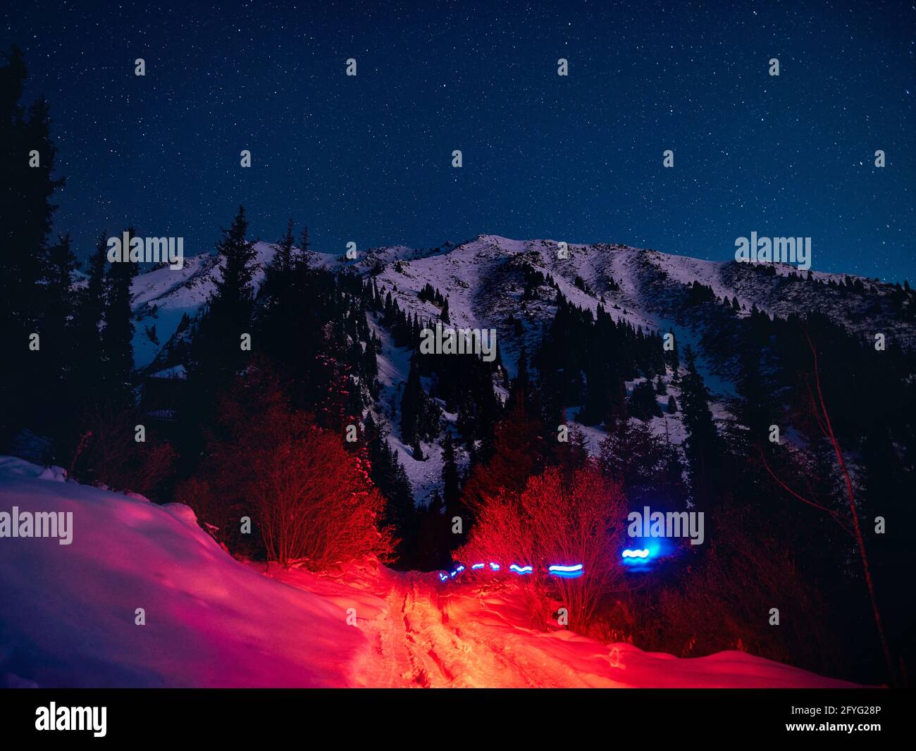 Abstract beam of red and blue glowing lights on the road at winter ...