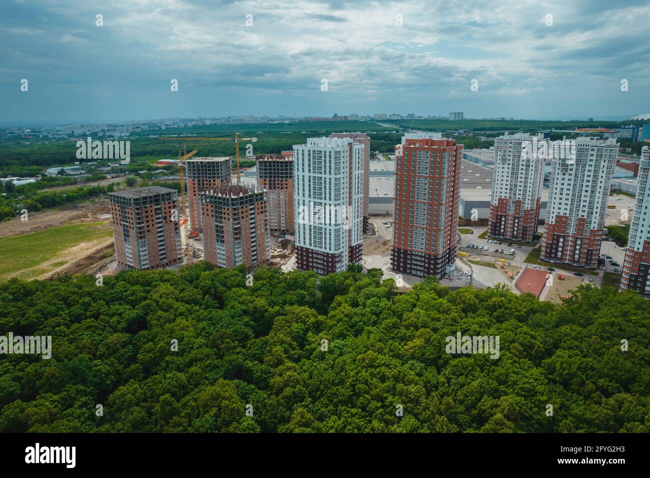 Construction yard of multistory living building with hoisting cranes ...
