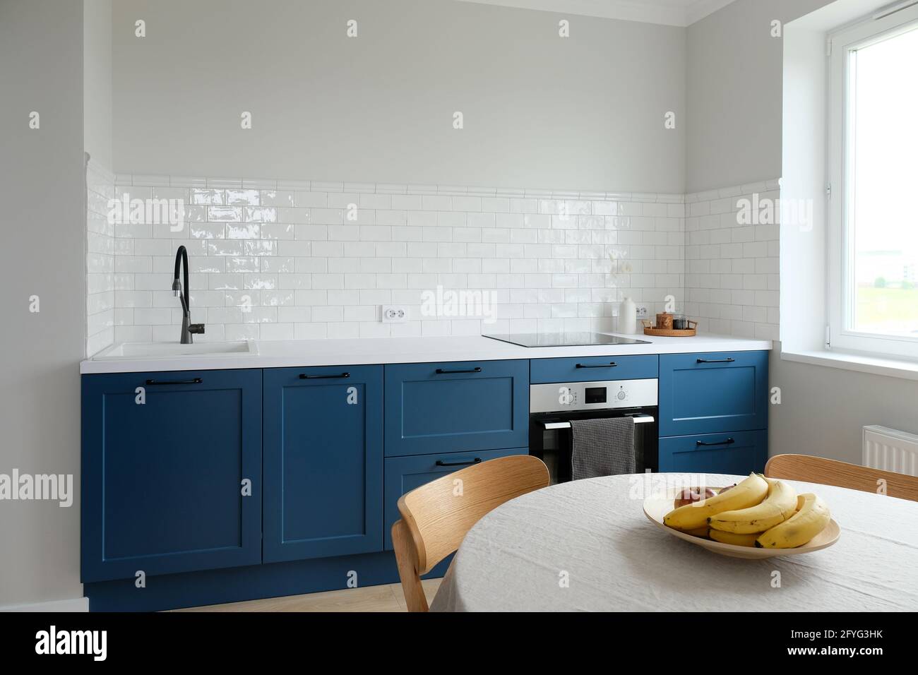Scandinavian interior design. Blue kitchen cabinets, dining table with ...