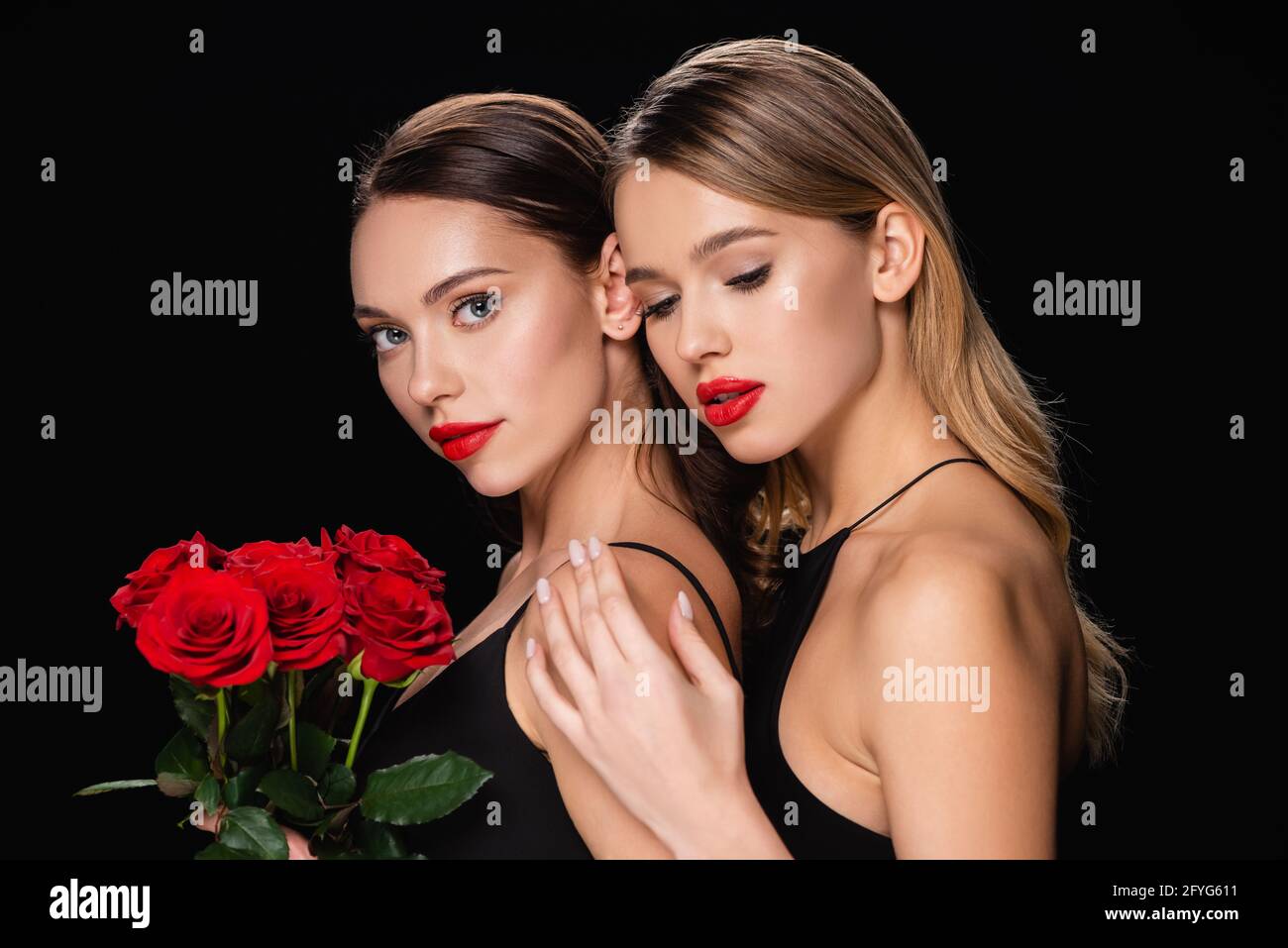 pretty woman touching shoulder of charming friend holding red roses ...