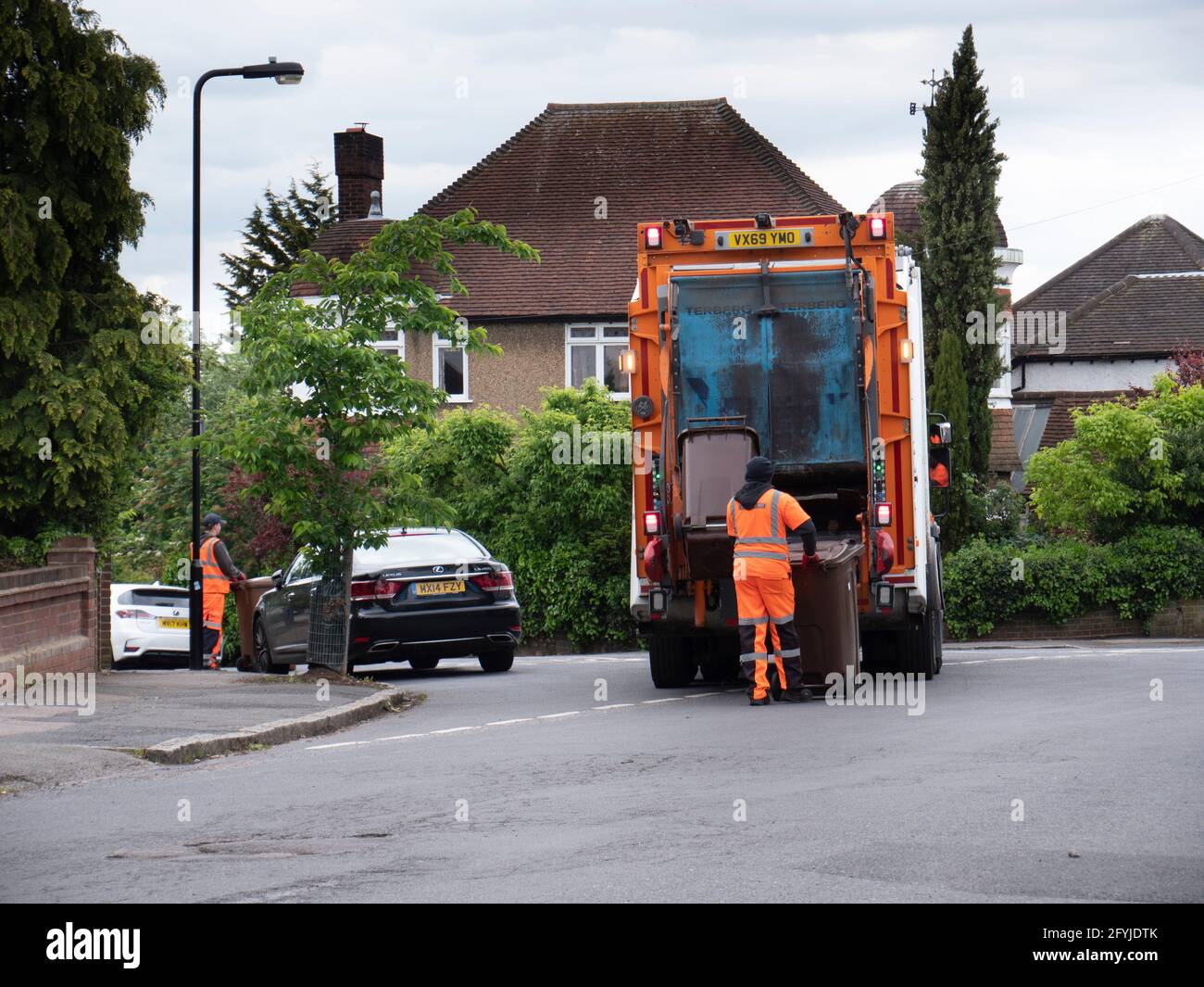 garbage refuse collectors emptying wheelie bin trash into Terberg ...